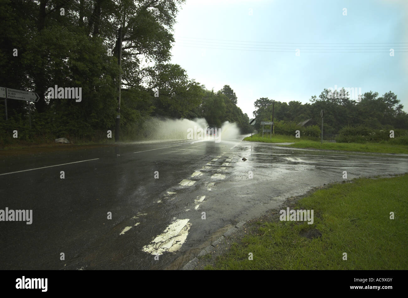 Car driving through flooded road spraying water after heavy rain Stock ...