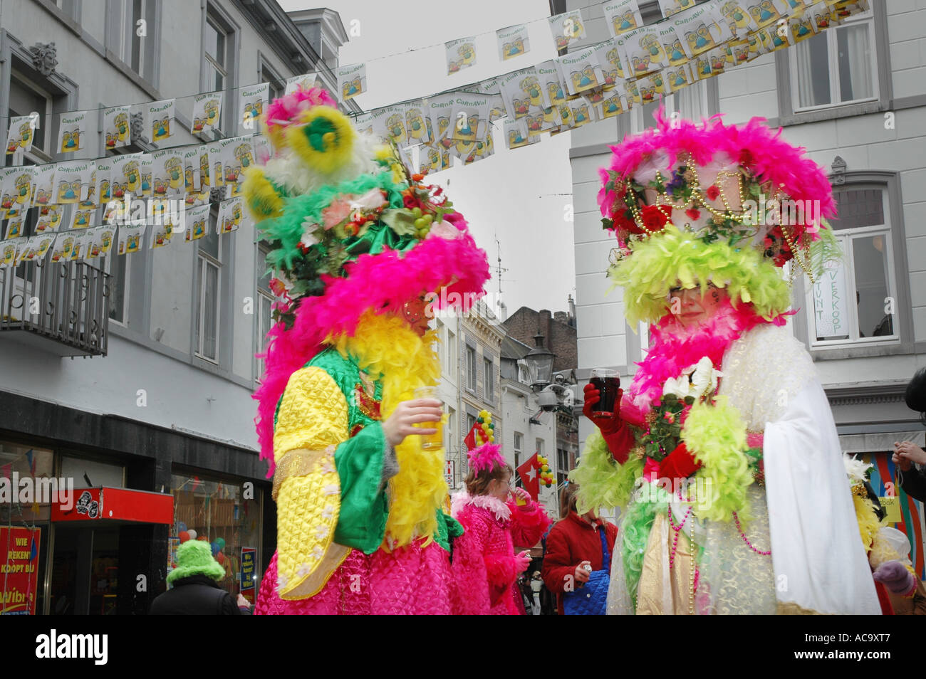 two colourful ladies in street carnival dressed in garish colours ...