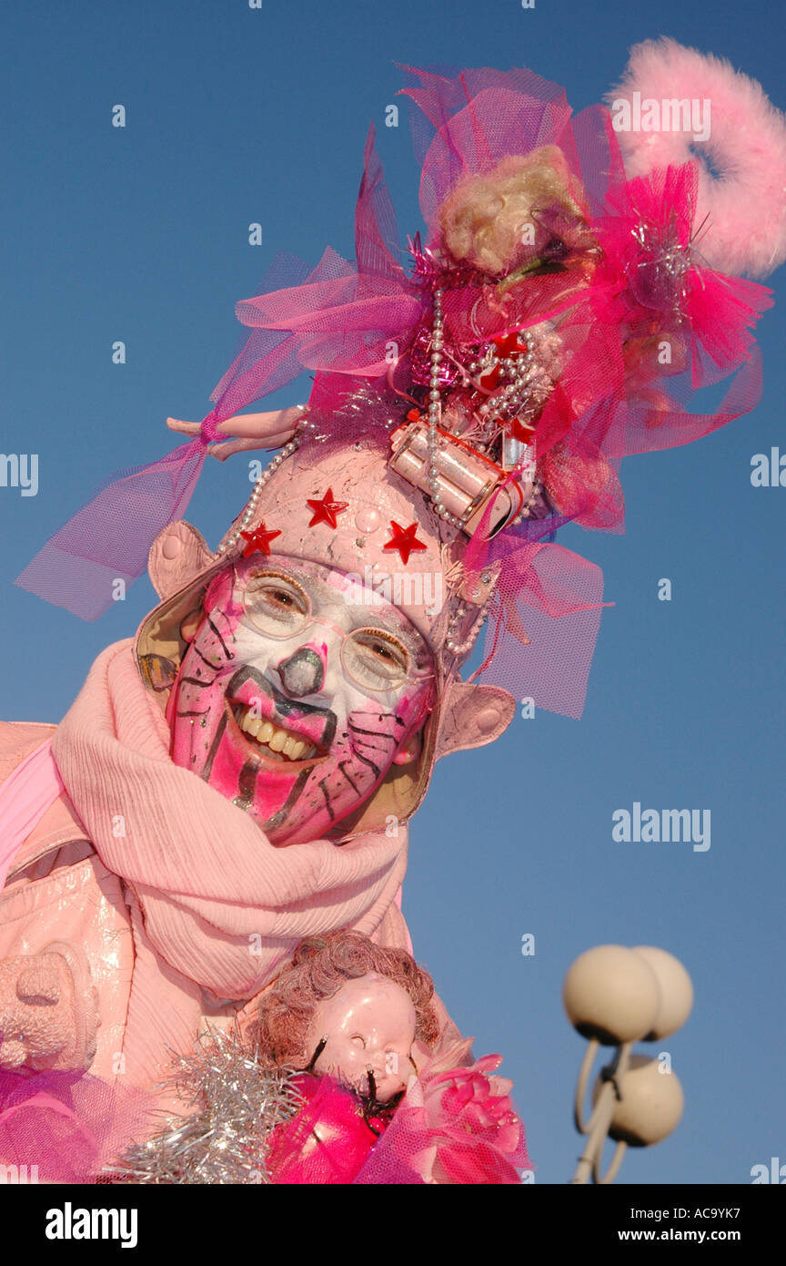 Man in pink carnival costume with homemade hat collage in garish pink ...