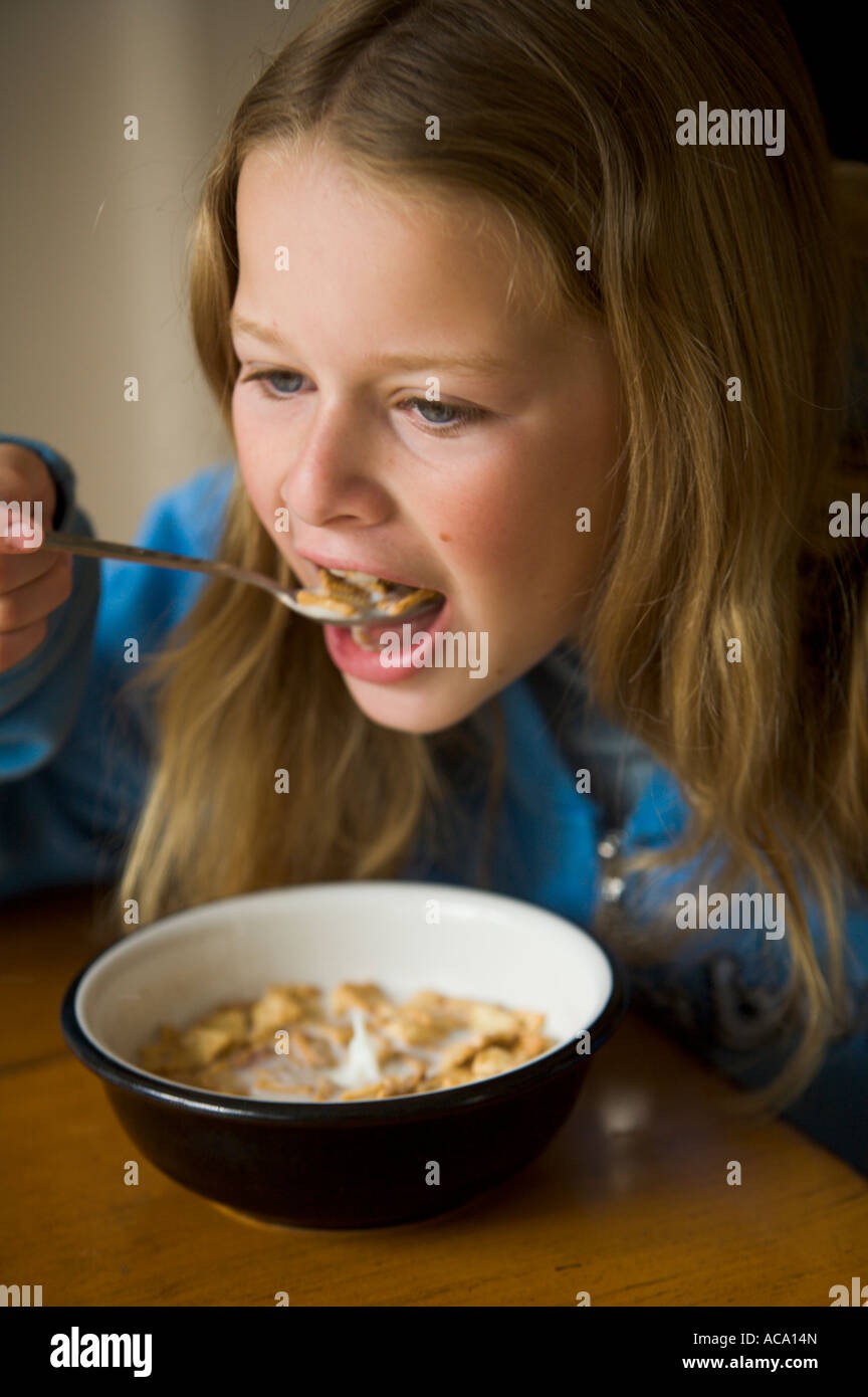 A ten year old girl eats breakfast model released Stock Photo - Alamy