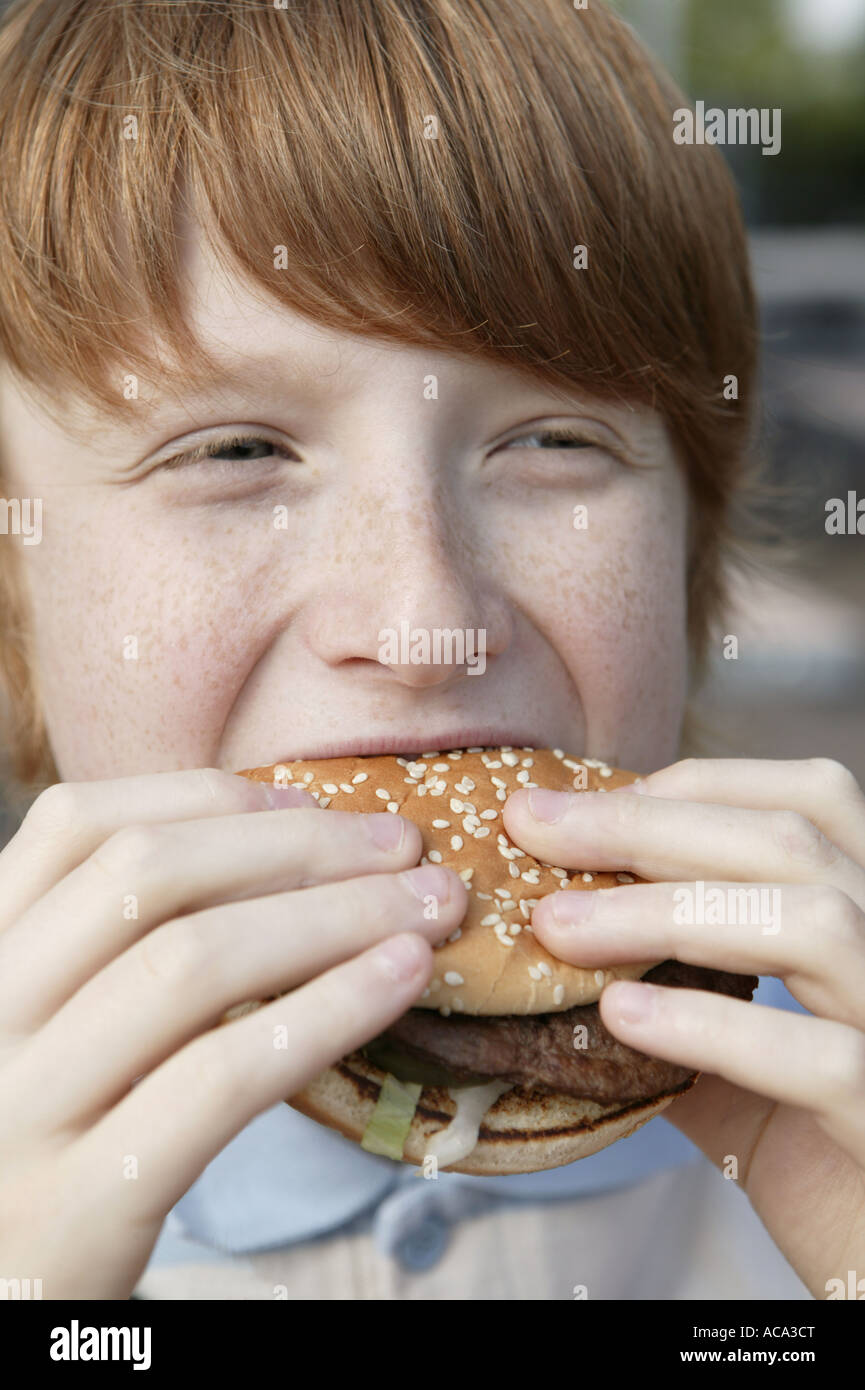 Boy eats a burger Stock Photo - Alamy