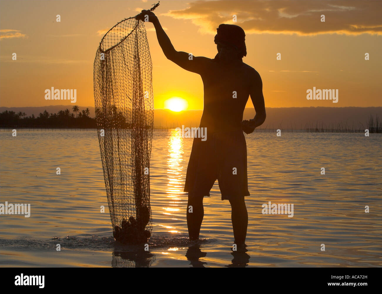 Fisherman with net in evening light, Philippines Stock Photo - Alamy