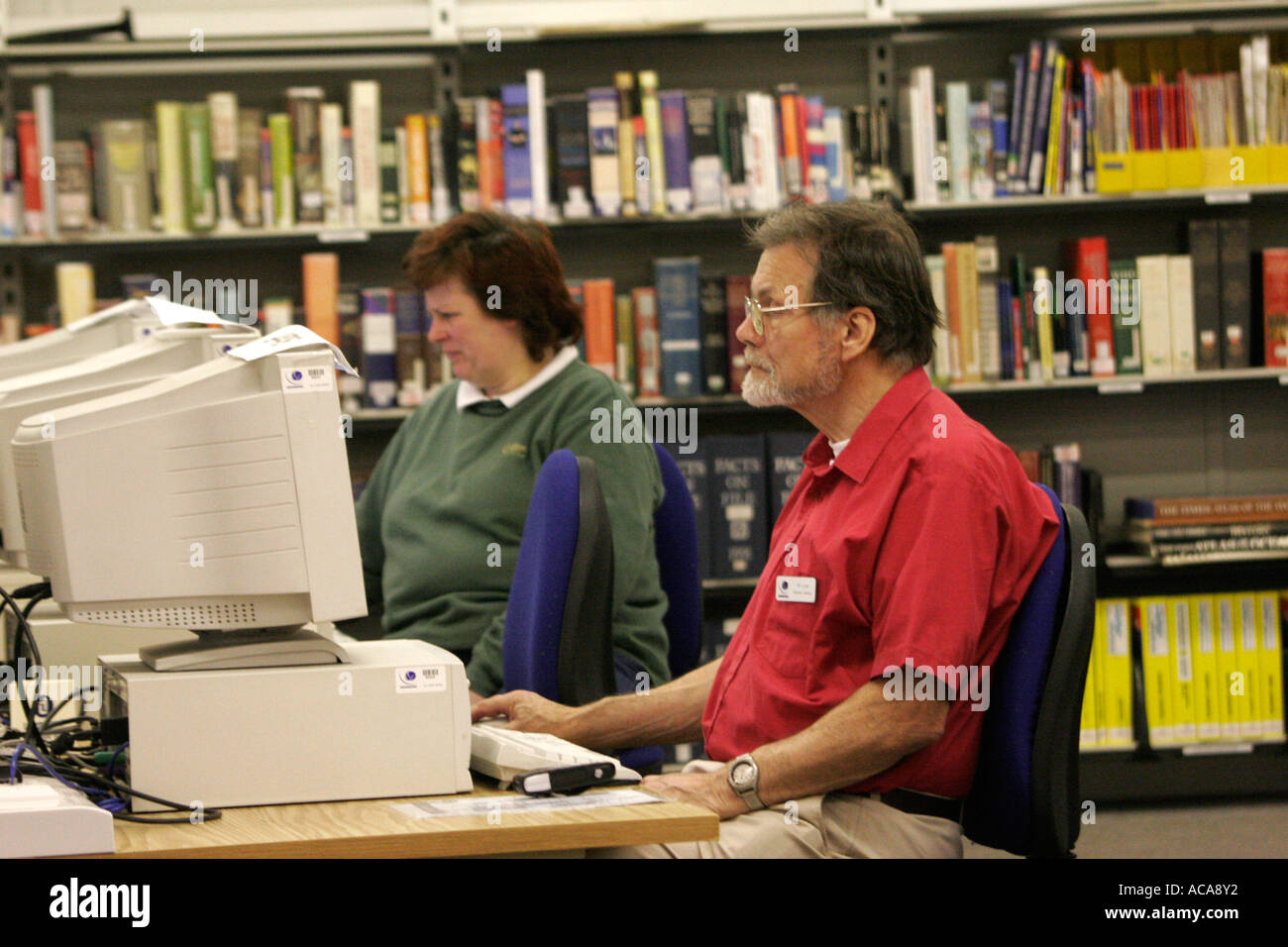 Male & female mature students using computers at adult education centre ...