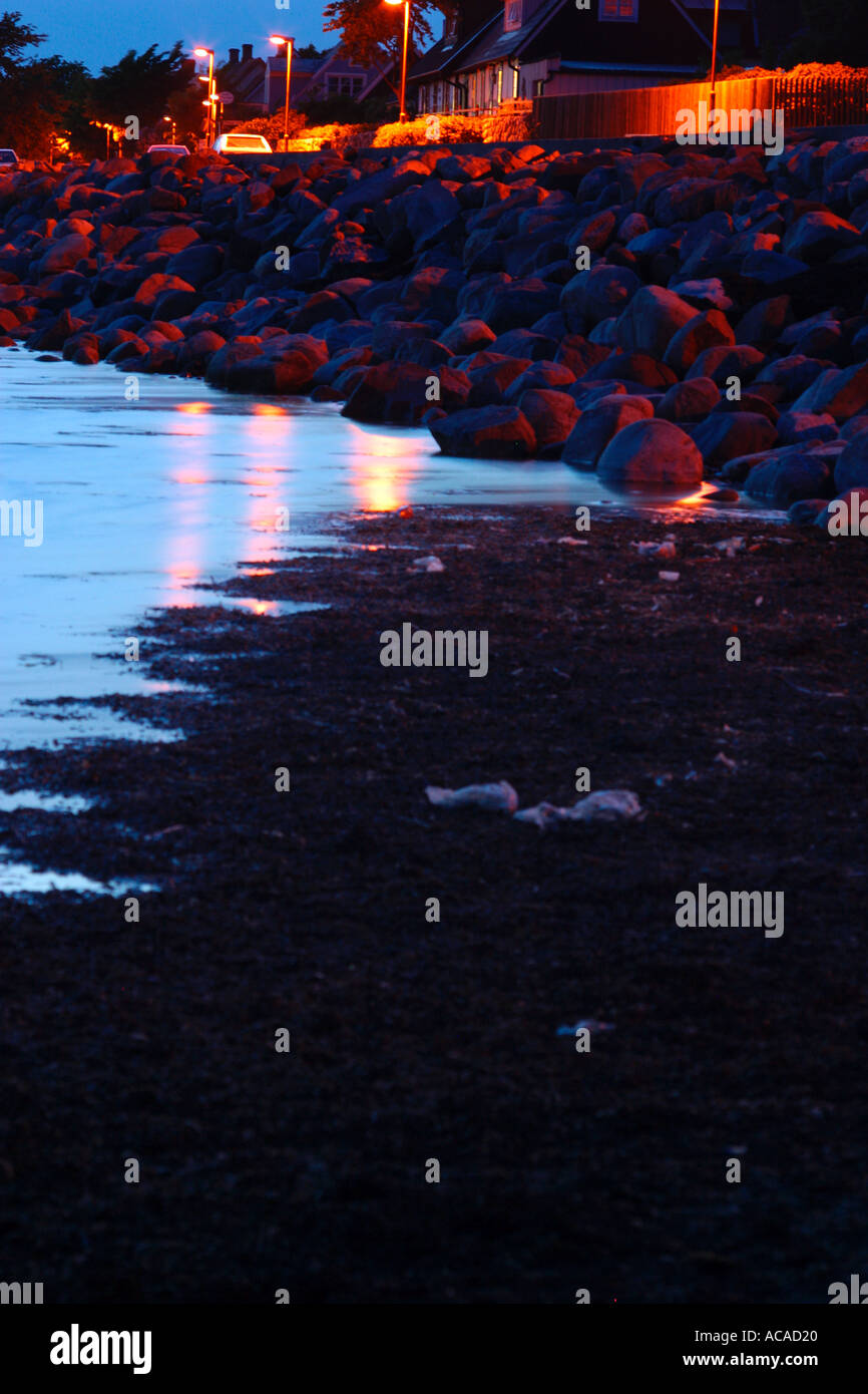 Seaside at night with street lamps reflecting in the water Stock Photo ...