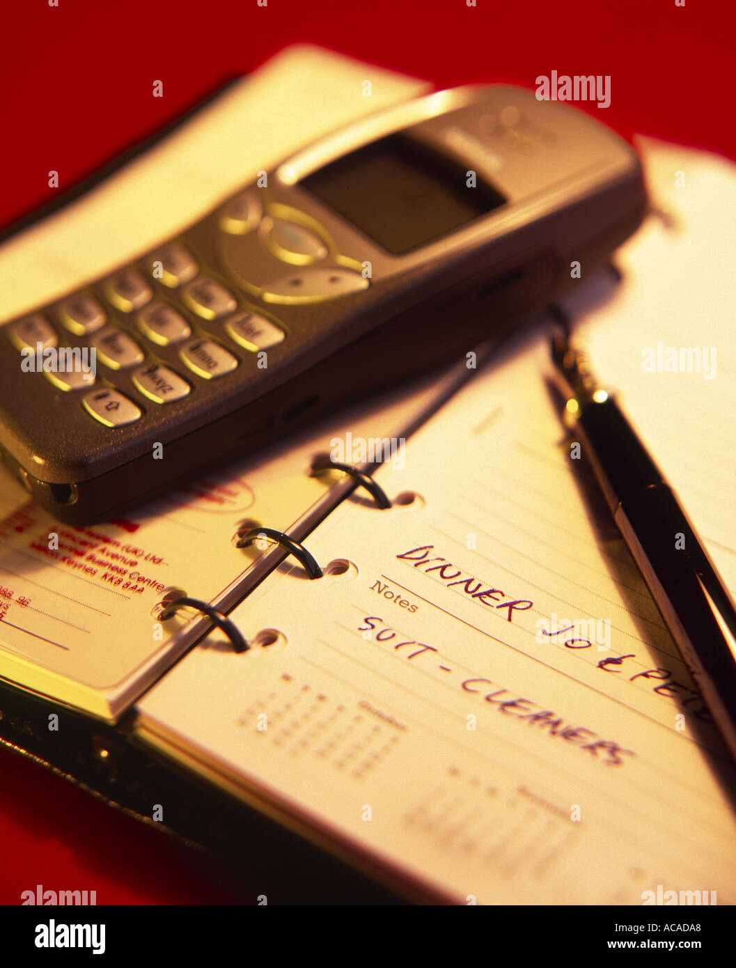 Mobile phone pen resting on a diary against a red background Stock ...