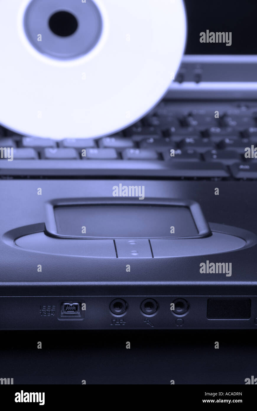 Computer laptop with compact disc in low light Stock Photo - Alamy