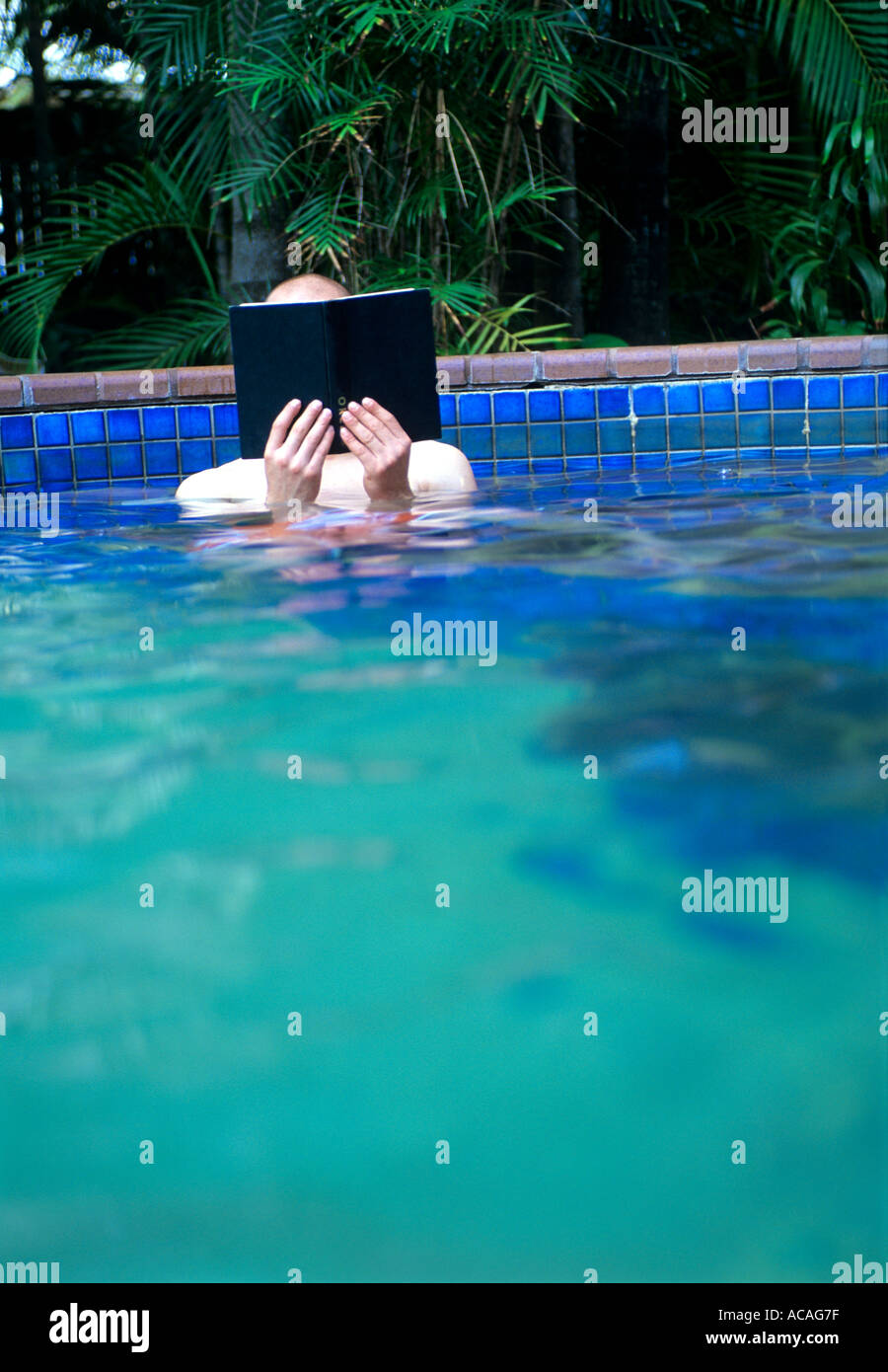 man reading book in swimming pool Stock Photo - Alamy