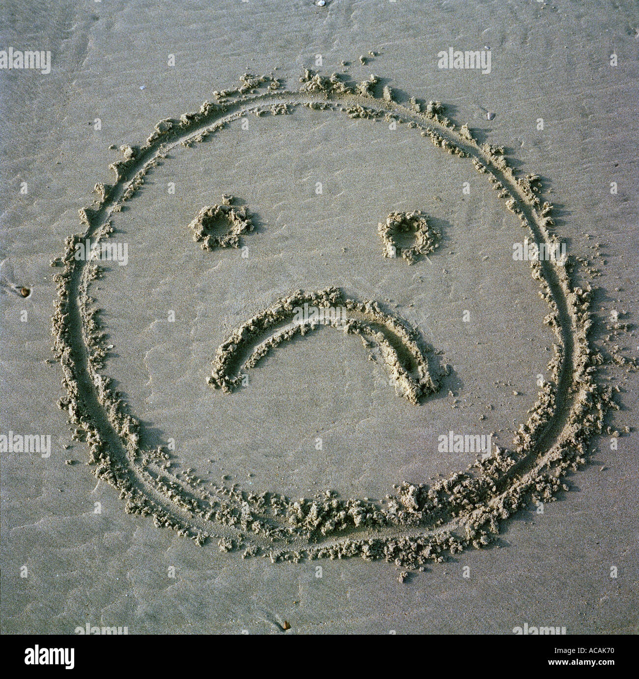 sad face in sand Stock Photo - Alamy
