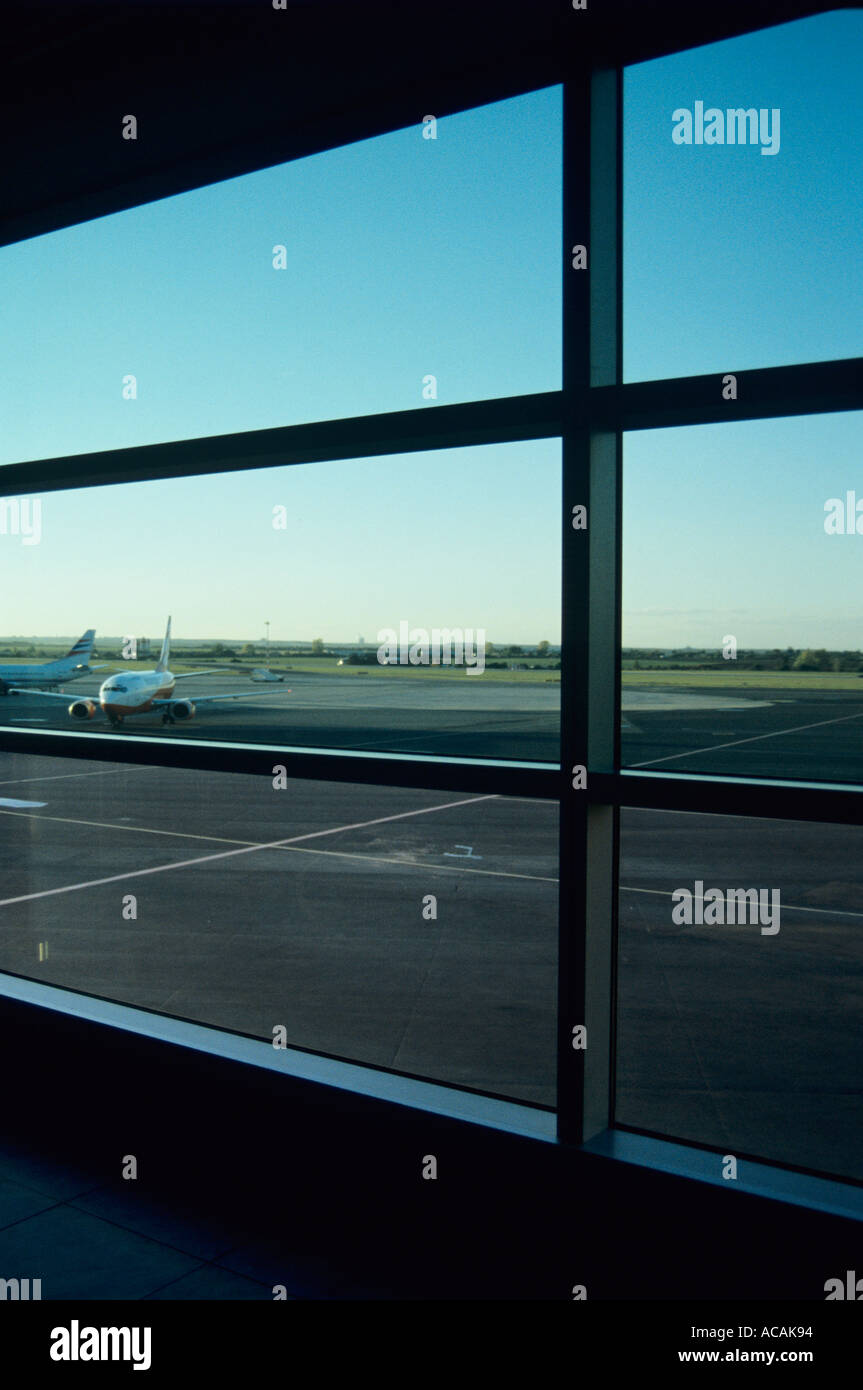 View from airport window onto plane and runway at dusk Stock Photo - Alamy