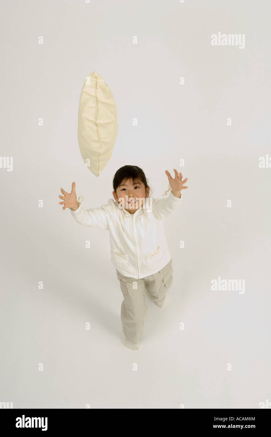 Girl throwing cushion Stock Photo - Alamy