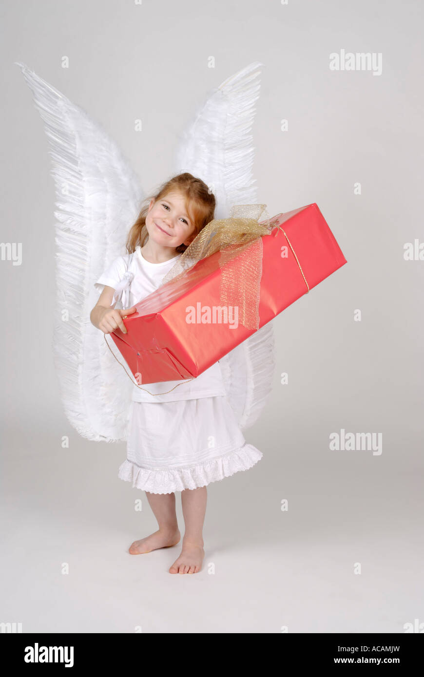 Little christmas angel with a christmas present Stock Photo - Alamy