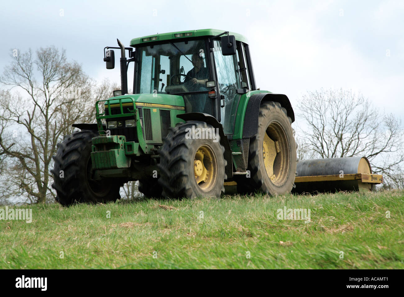 Tractor rolling hay field 7 Stock Photo - Alamy