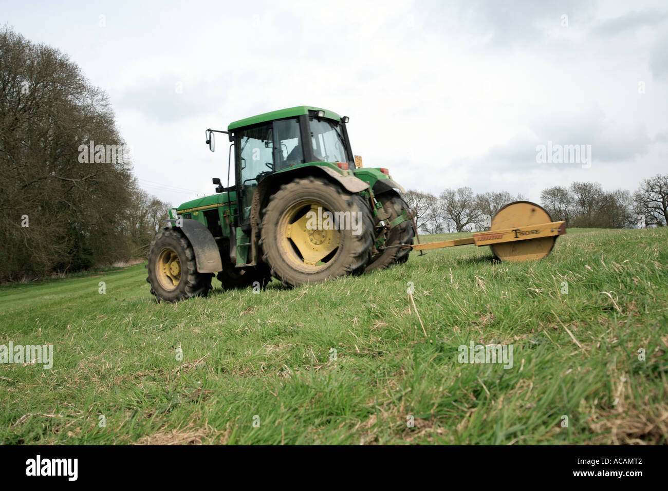 Tractor rolling hay field 6 Stock Photo - Alamy