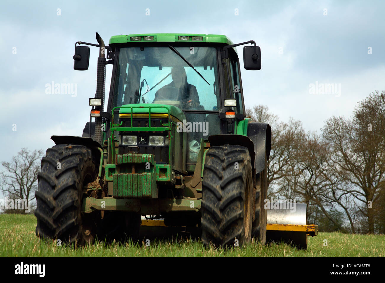 Tractor rolling hay field 3 Stock Photo - Alamy