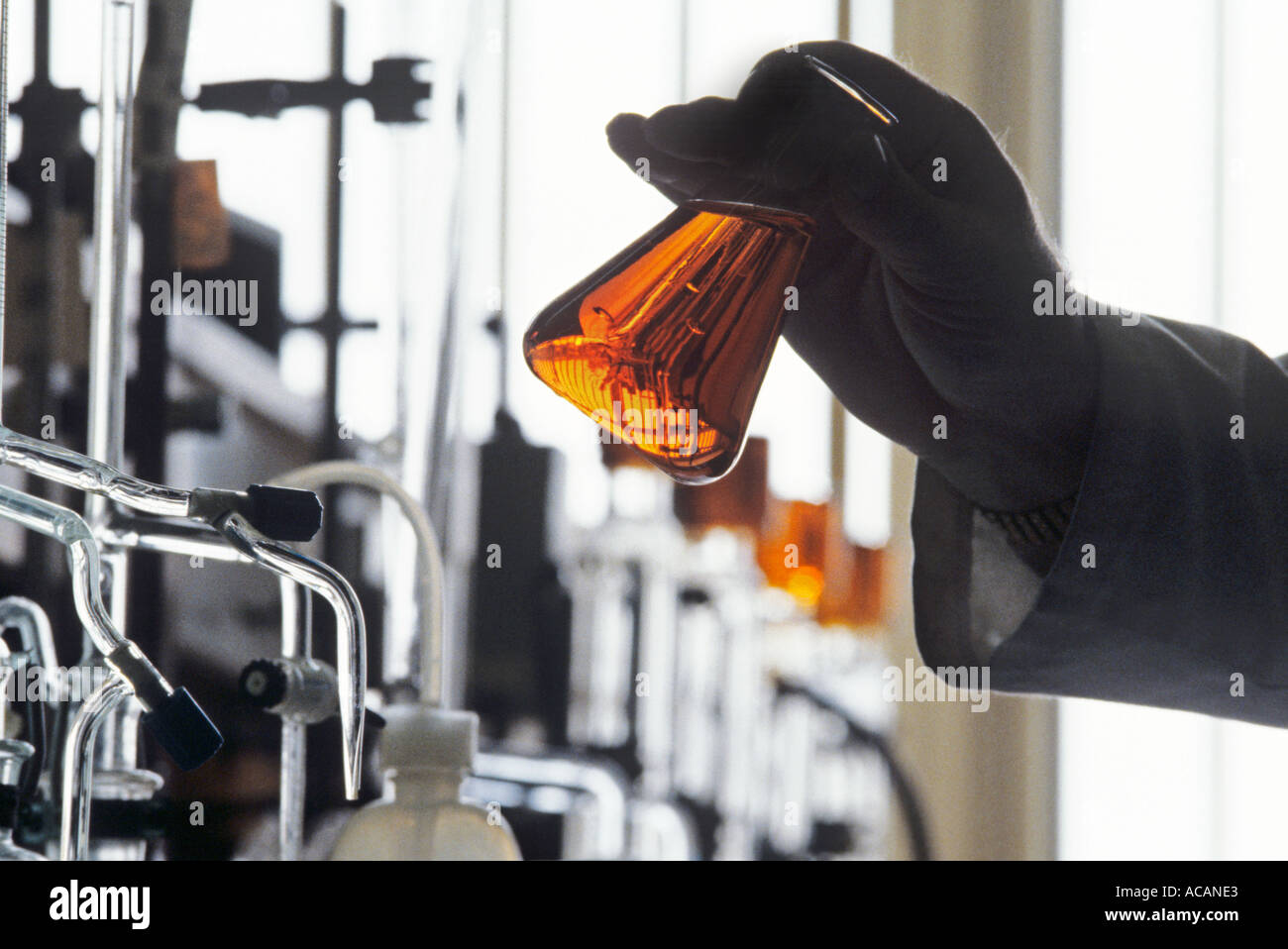 Hand holding flask of liquid in science laboratory Stock Photo - Alamy