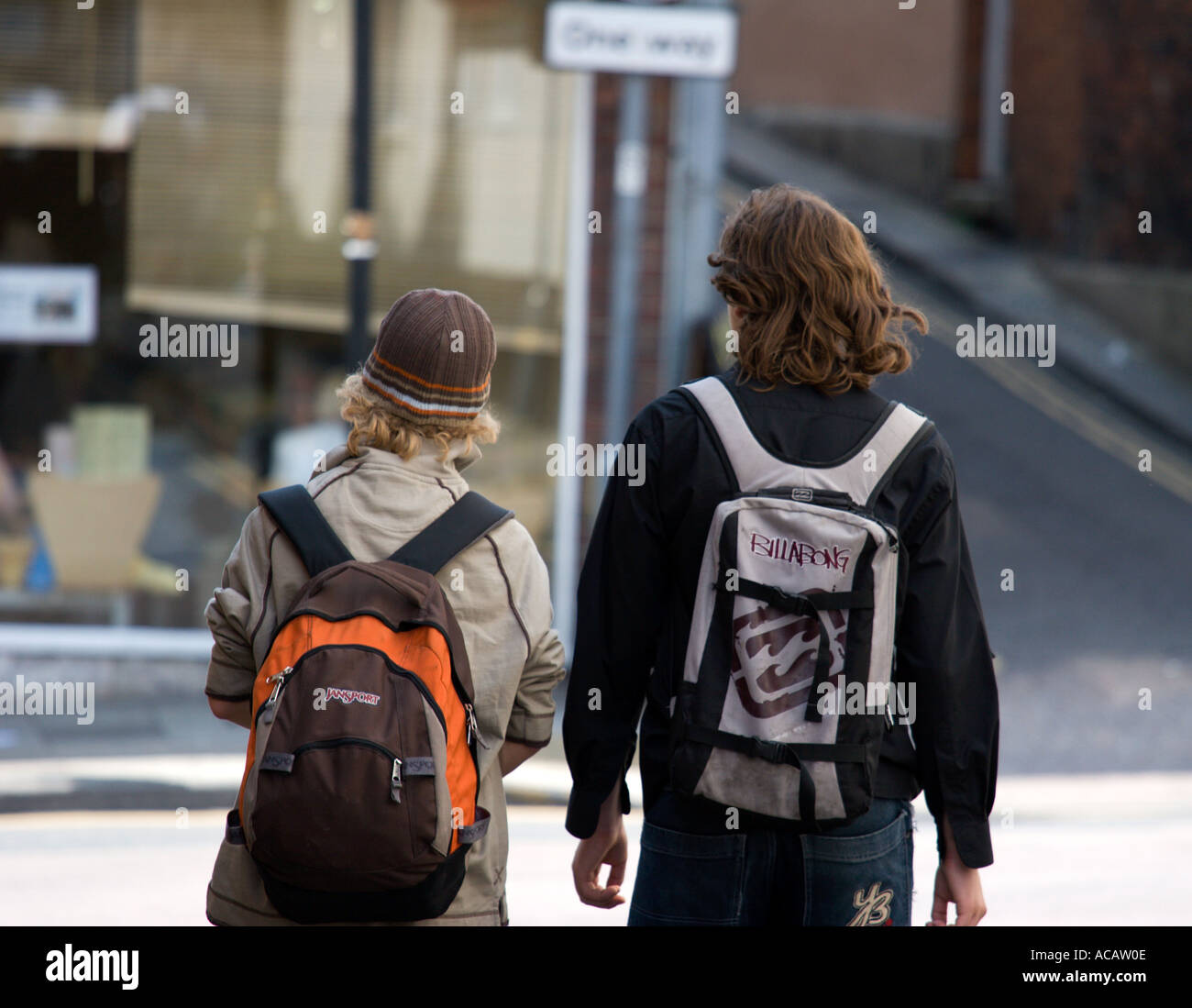 A back view of Two young fashionable boys with backpacks Stock Photo ...