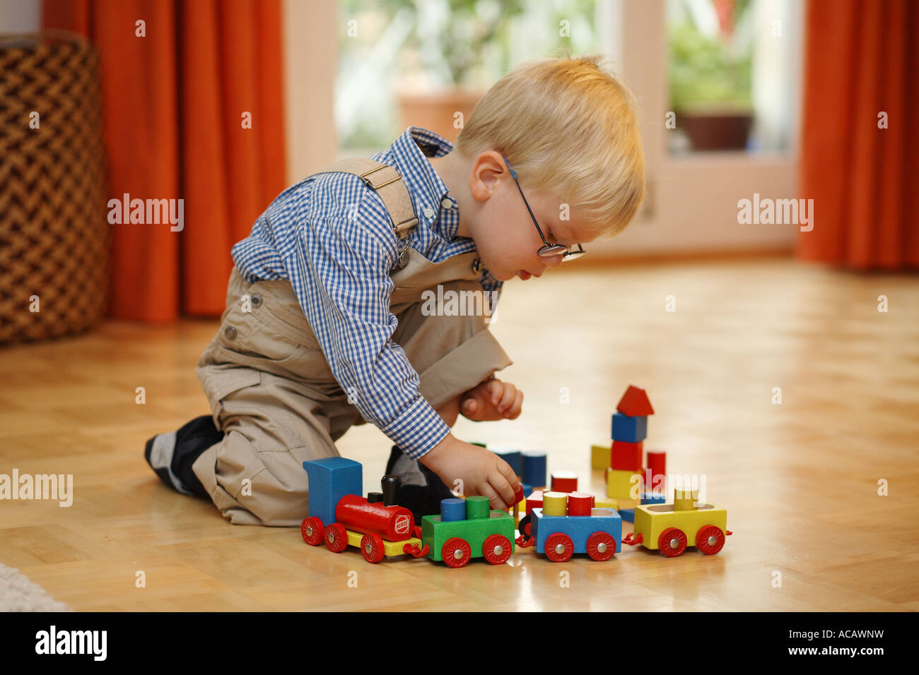 Little boy plays with a wooden toy-train Stock Photo - Alamy