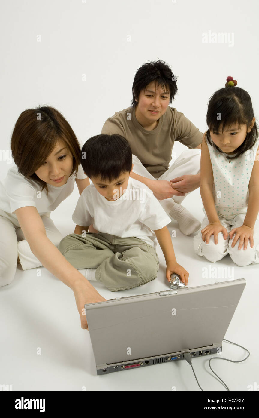 Family watching son use computer Stock Photo - Alamy