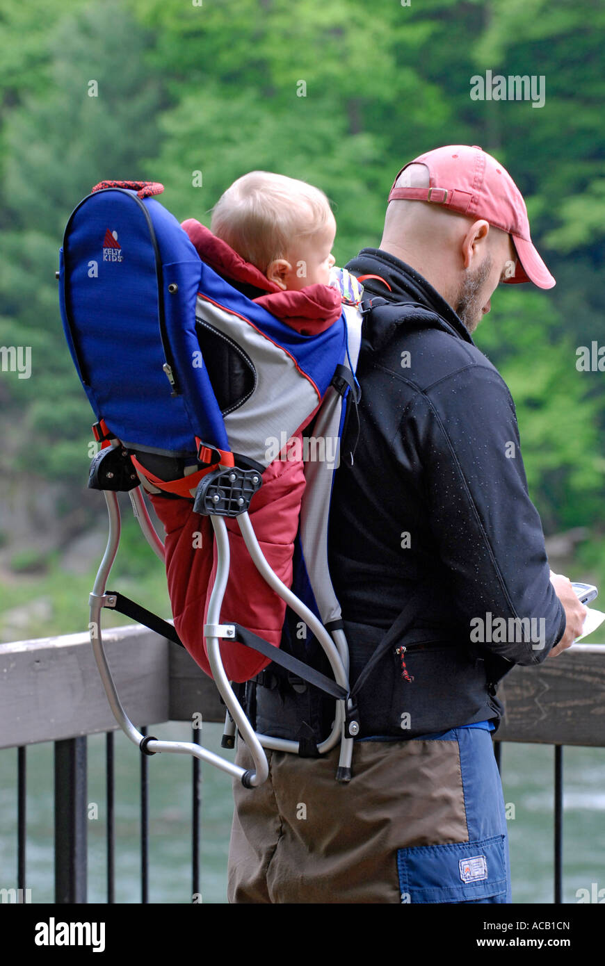 Father carrying son in a backpack carrier Stock Photo - Alamy