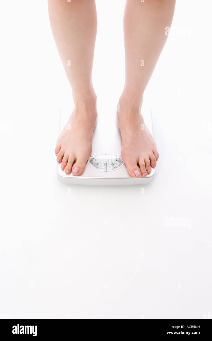 Woman standing on bathroom scale Stock Photo - Alamy