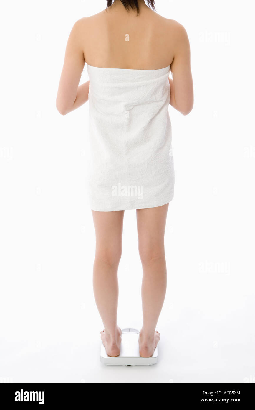 Woman standing on bathroom scale Stock Photo - Alamy