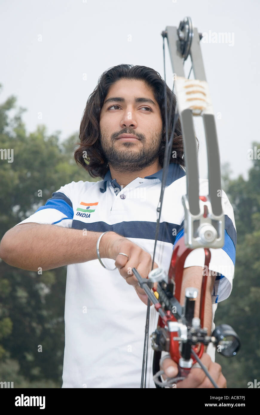 Low angle view of a young man holding a bow and arrow Stock Photo - Alamy