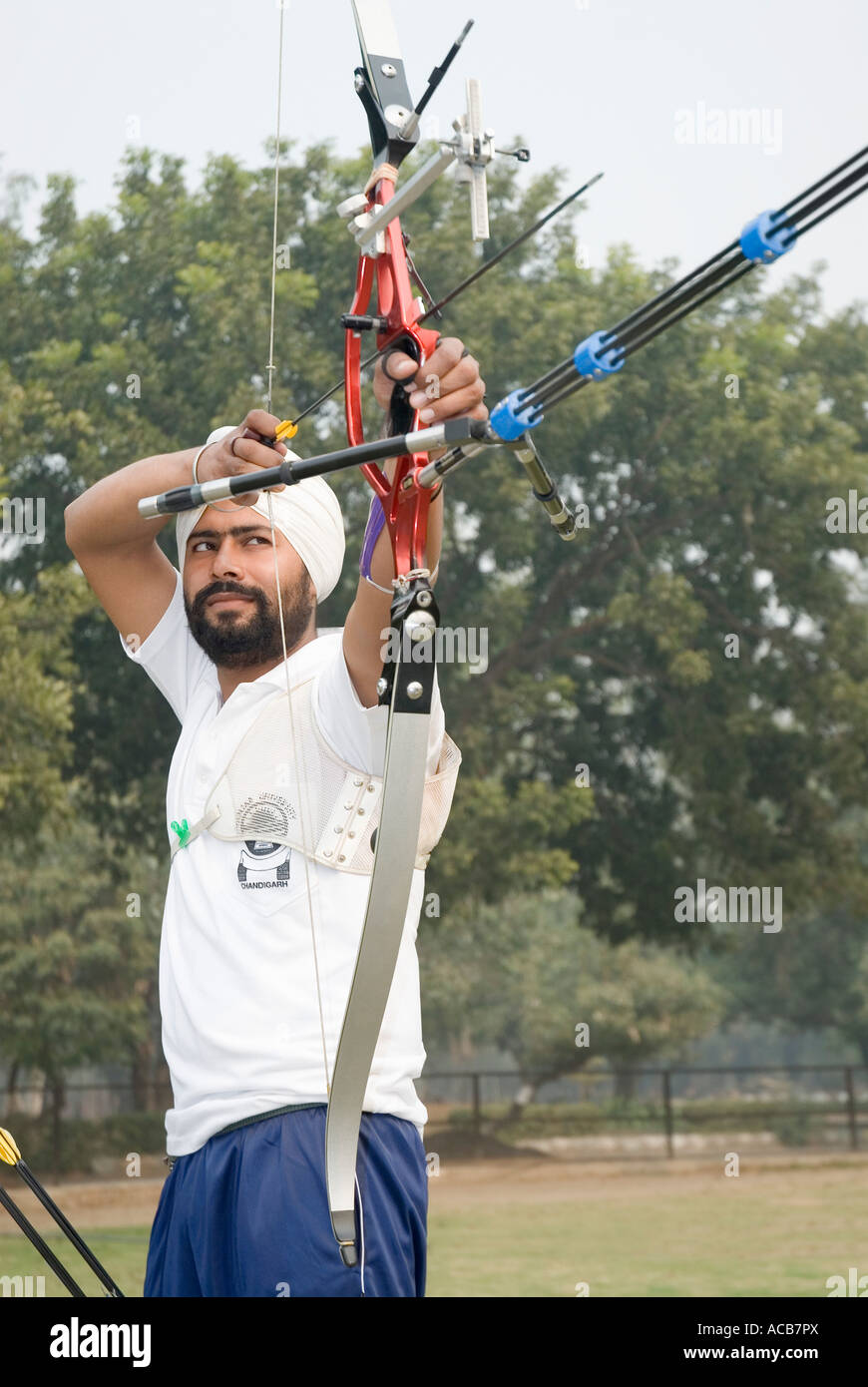 Low angle view of a young man aiming with a bow and arrow Stock Photo ...