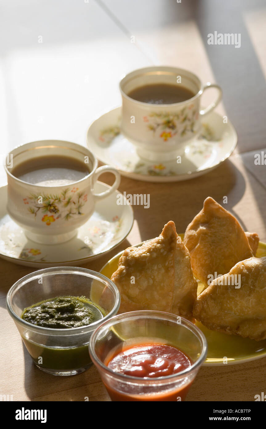 Two cups of tea served with Indian snacks and condiments Stock Photo ...