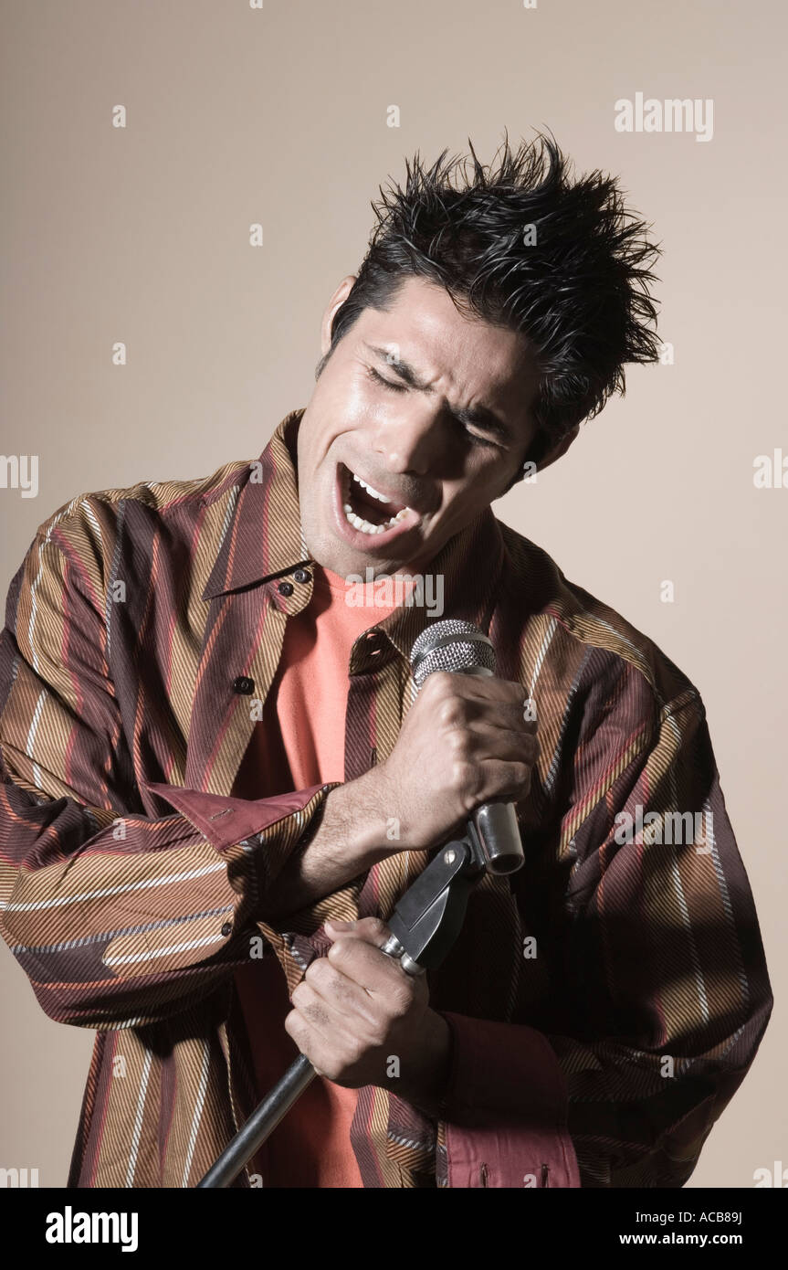 Close-up of a young man singing into a microphone Stock Photo - Alamy