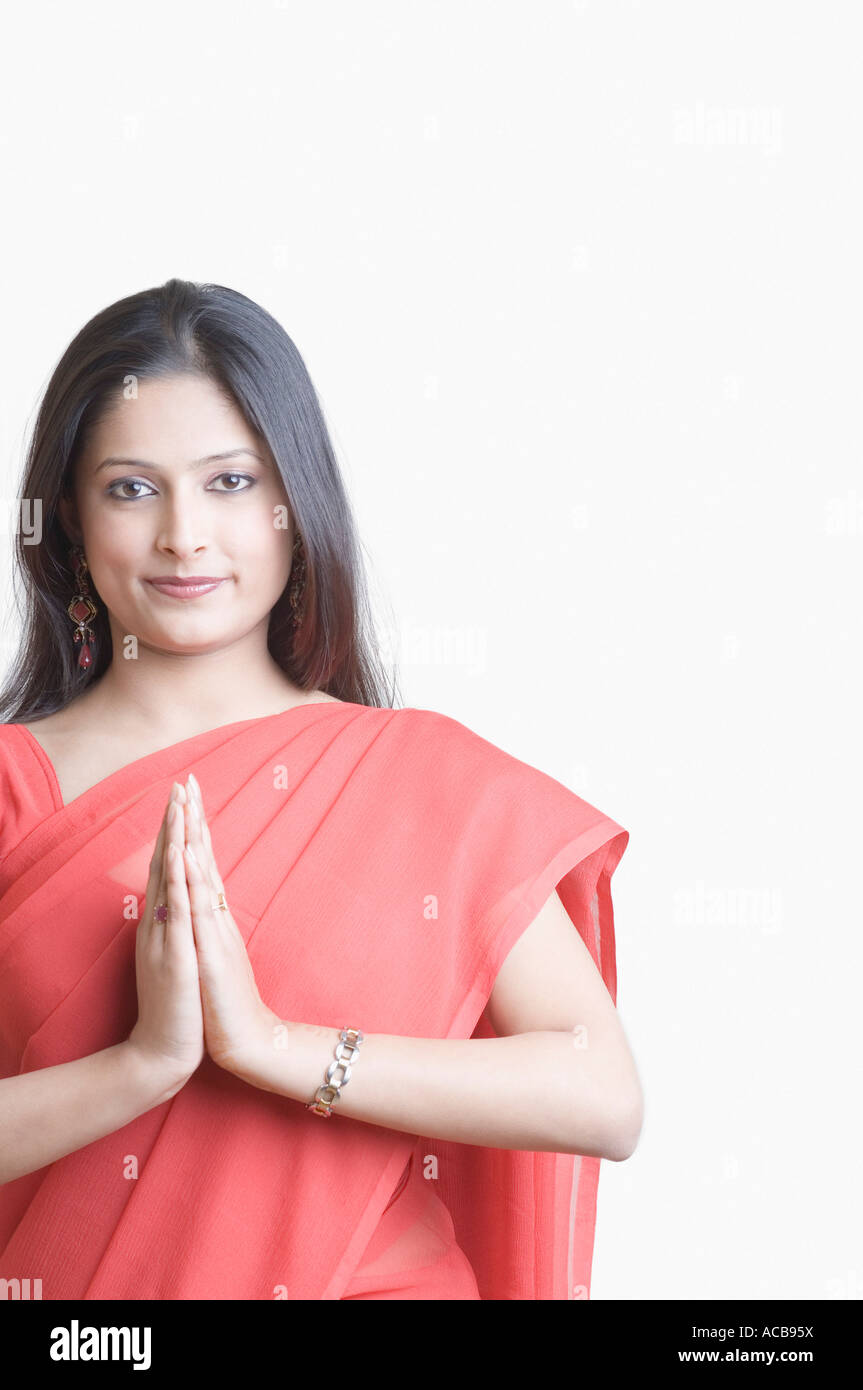 Portrait of a young woman making a greeting gesture Stock Photo - Alamy