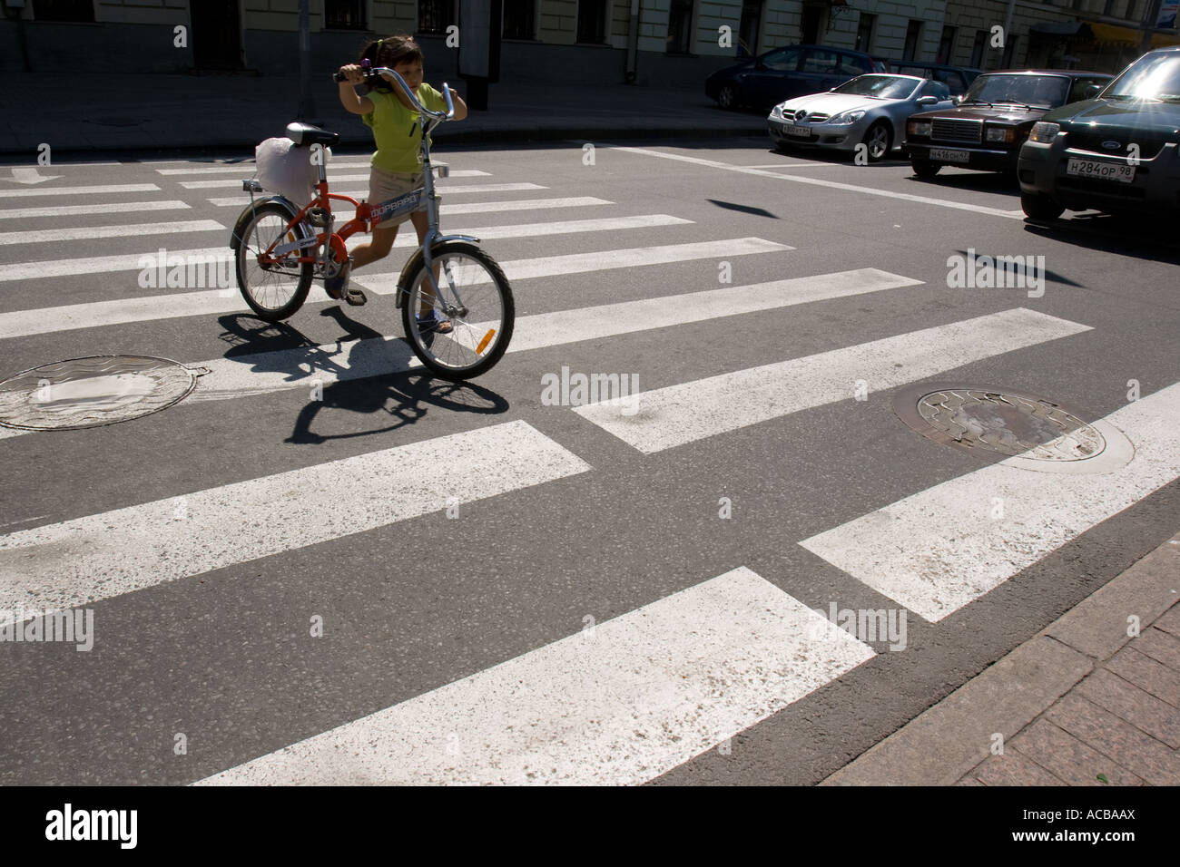 Girl with a bicycle crossing the road at a pedestrian crossing Stock Photo - Alamy
