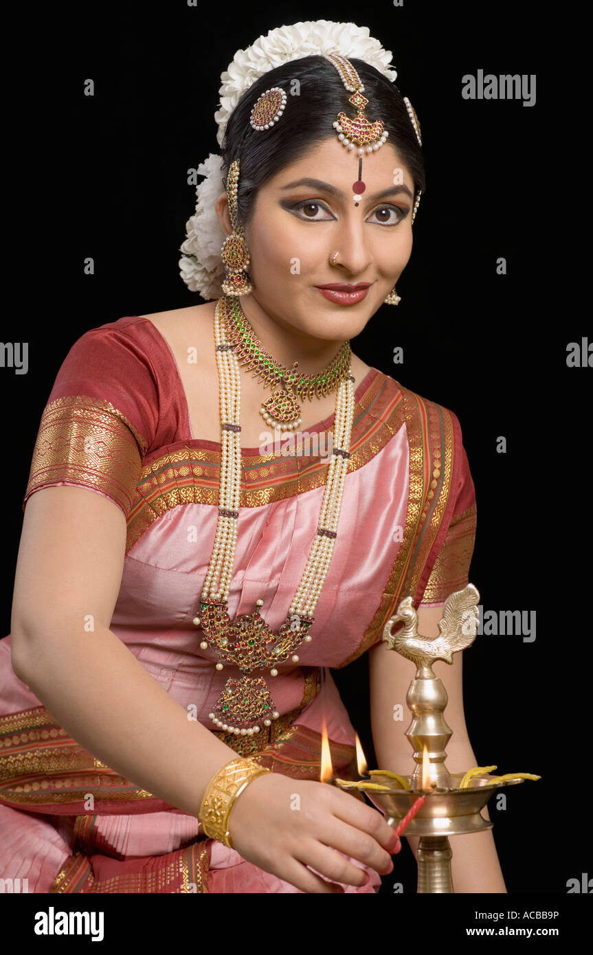 Portrait of a young woman lighting a ceremonial lamp Stock Photo - Alamy