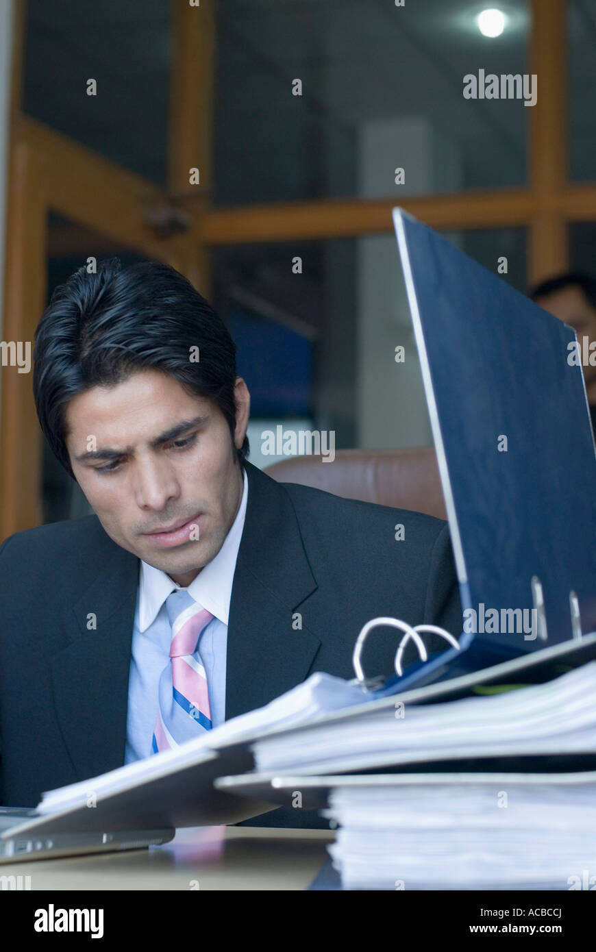 Businessman looking at a file in an office Stock Photo - Alamy