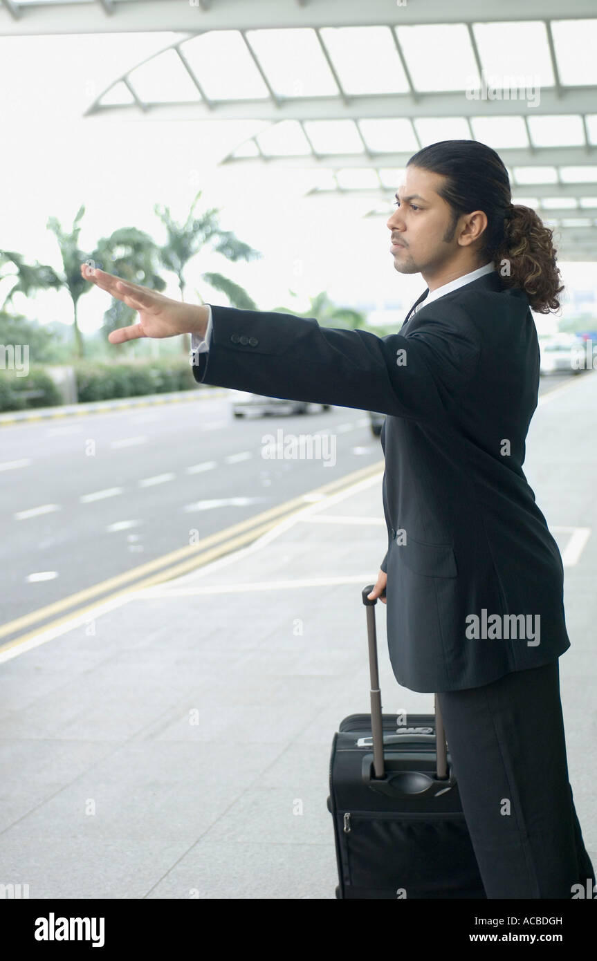Side profile of a businessman hailing a taxi Stock Photo - Alamy