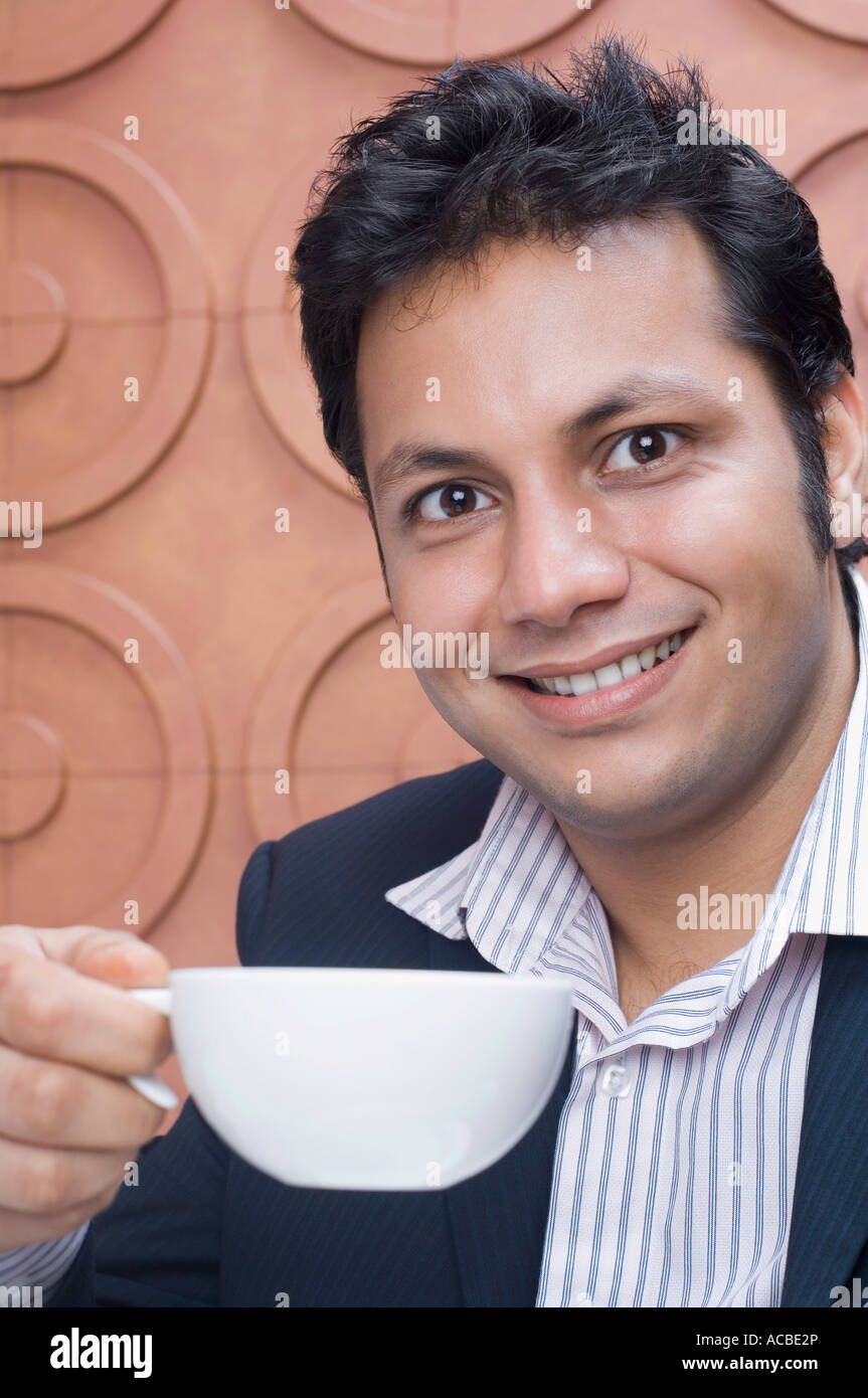 Portrait of a young man holding a cup of tea Stock Photo - Alamy