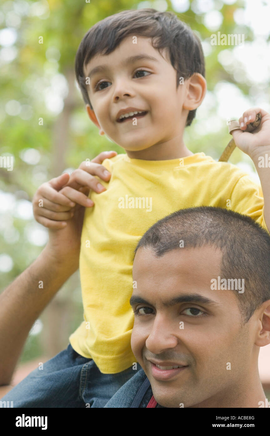 Close-up of a young man carrying a boy on his shoulders Stock Photo - Alamy