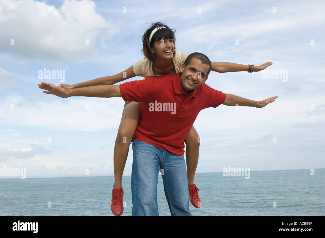 Portrait of a mid adult woman riding piggyback on a young man Stock ...