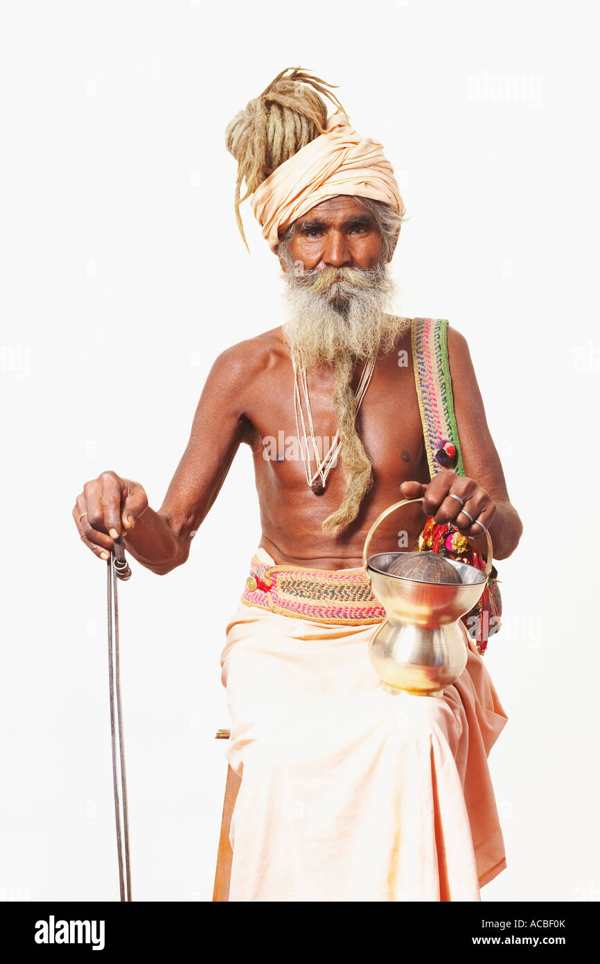 Portrait of a sadhu holding a cane and a kamandal Stock Photo - Alamy