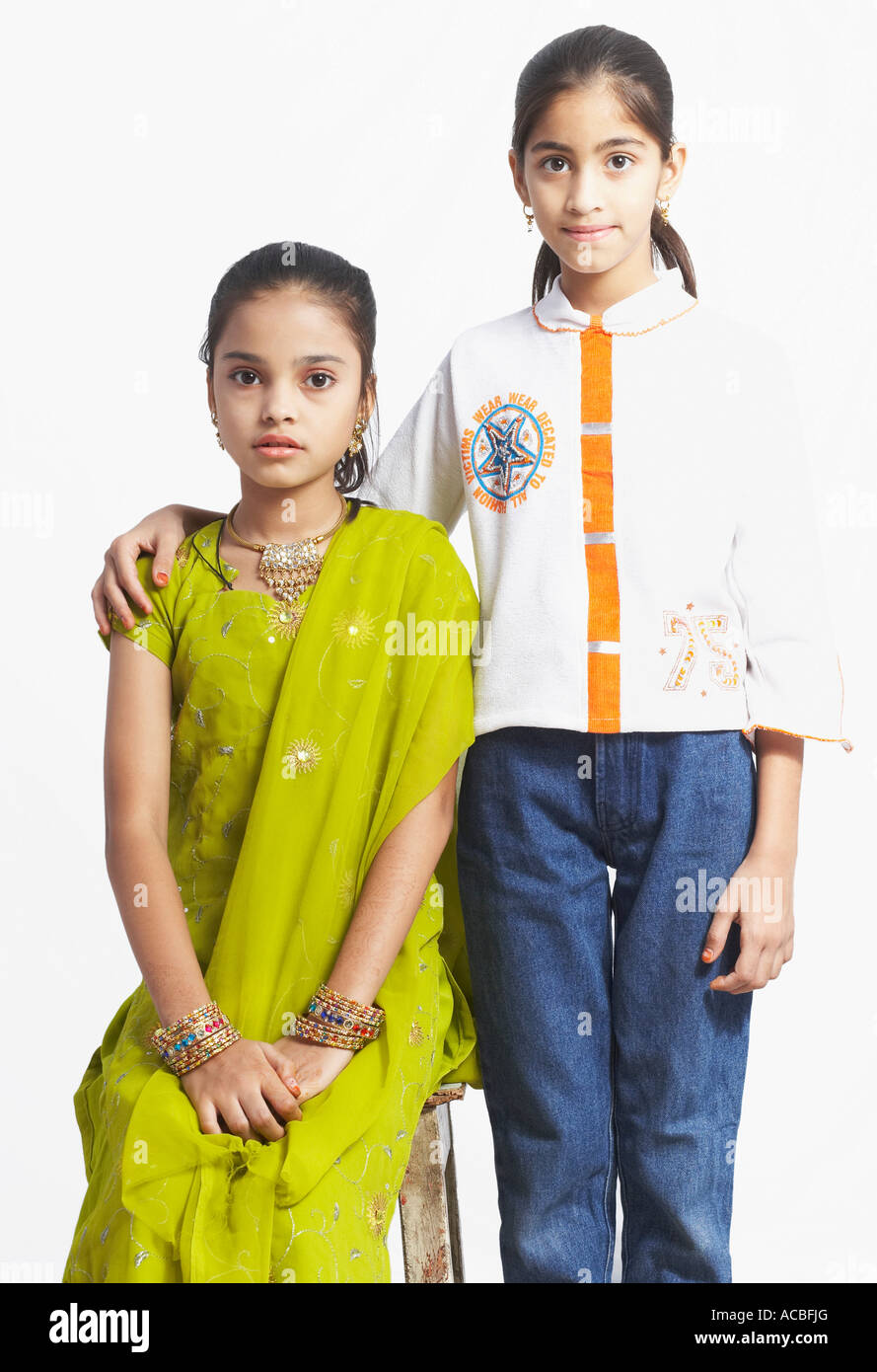 Portrait of a girl sitting with another girl standing beside her Stock ...