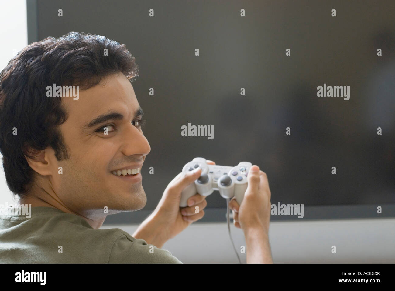 Close-up of a young man holding a joystick and smiling Stock Photo - Alamy