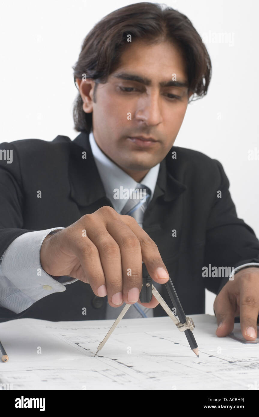 Architect using a drawing compass on a blueprint Stock Photo - Alamy