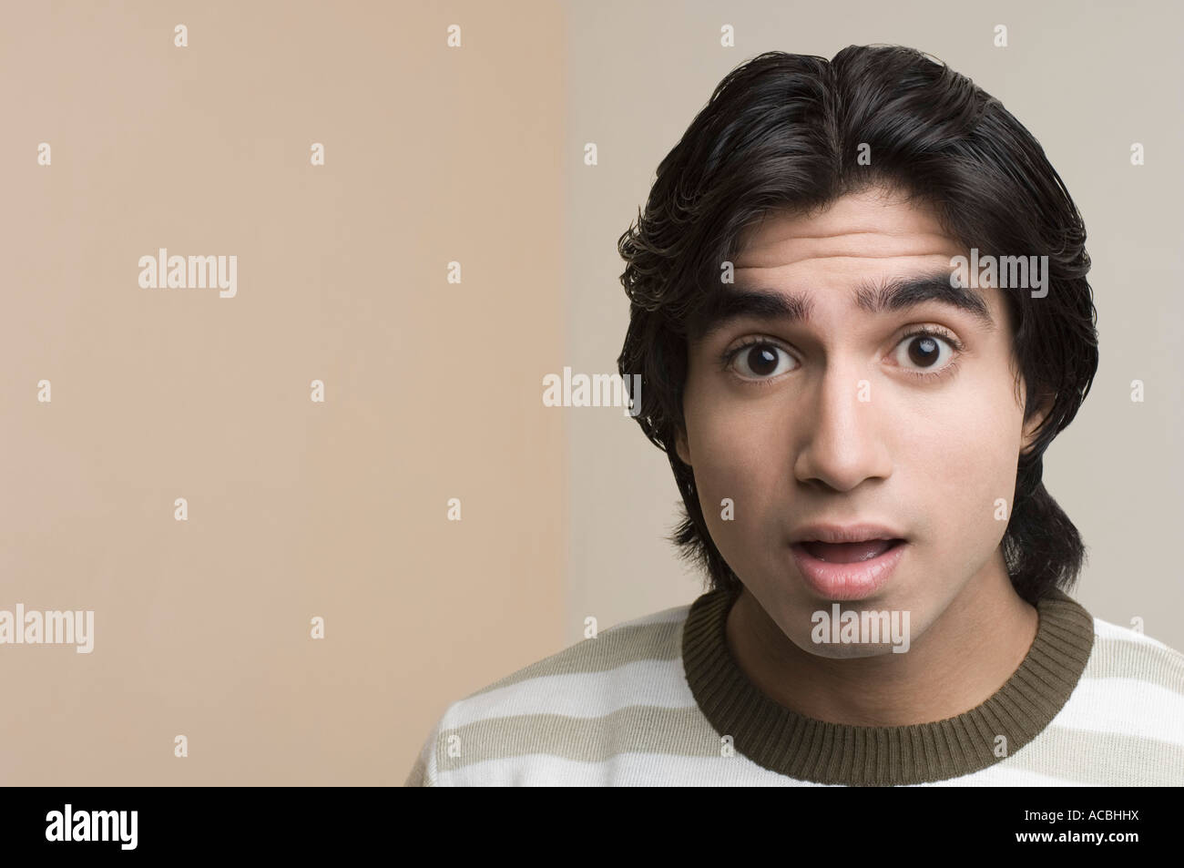 Portrait of a young man looking surprised Stock Photo - Alamy
