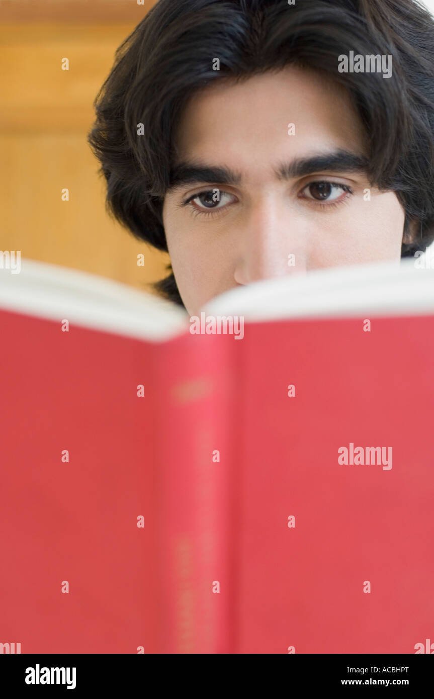 Close-up of a young man reading a book Stock Photo - Alamy