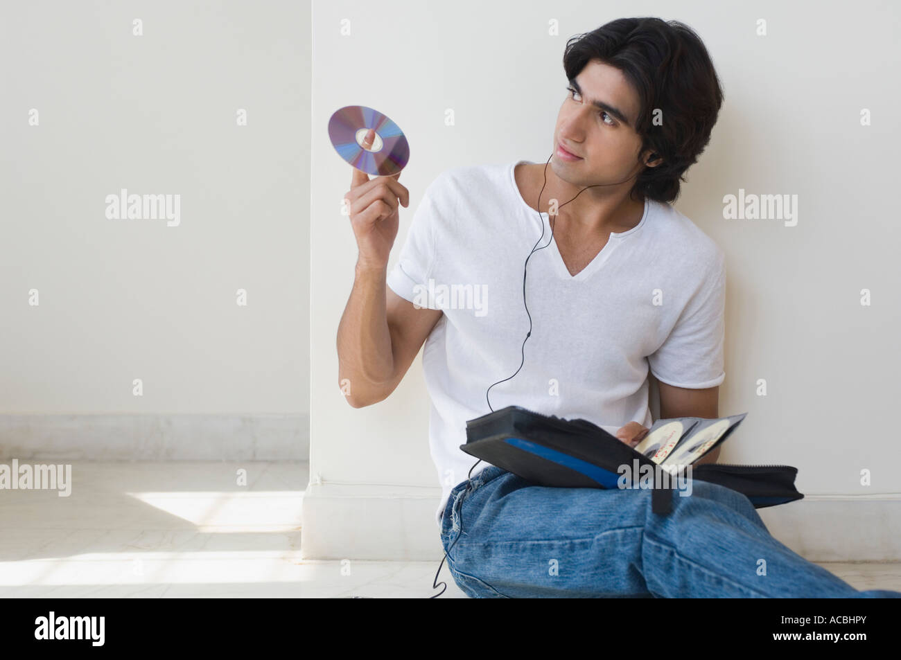 Young man listening to music and holding a CD Stock Photo - Alamy