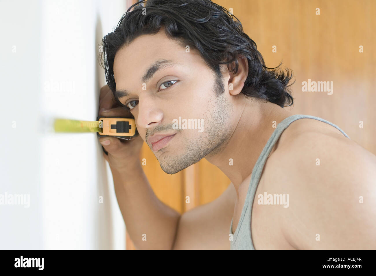 Close-up of a young man measuring a wall with a tape measure Stock ...