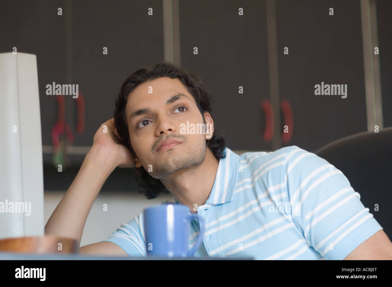 Close-up of a young man thinking in front of a computer Stock Photo - Alamy