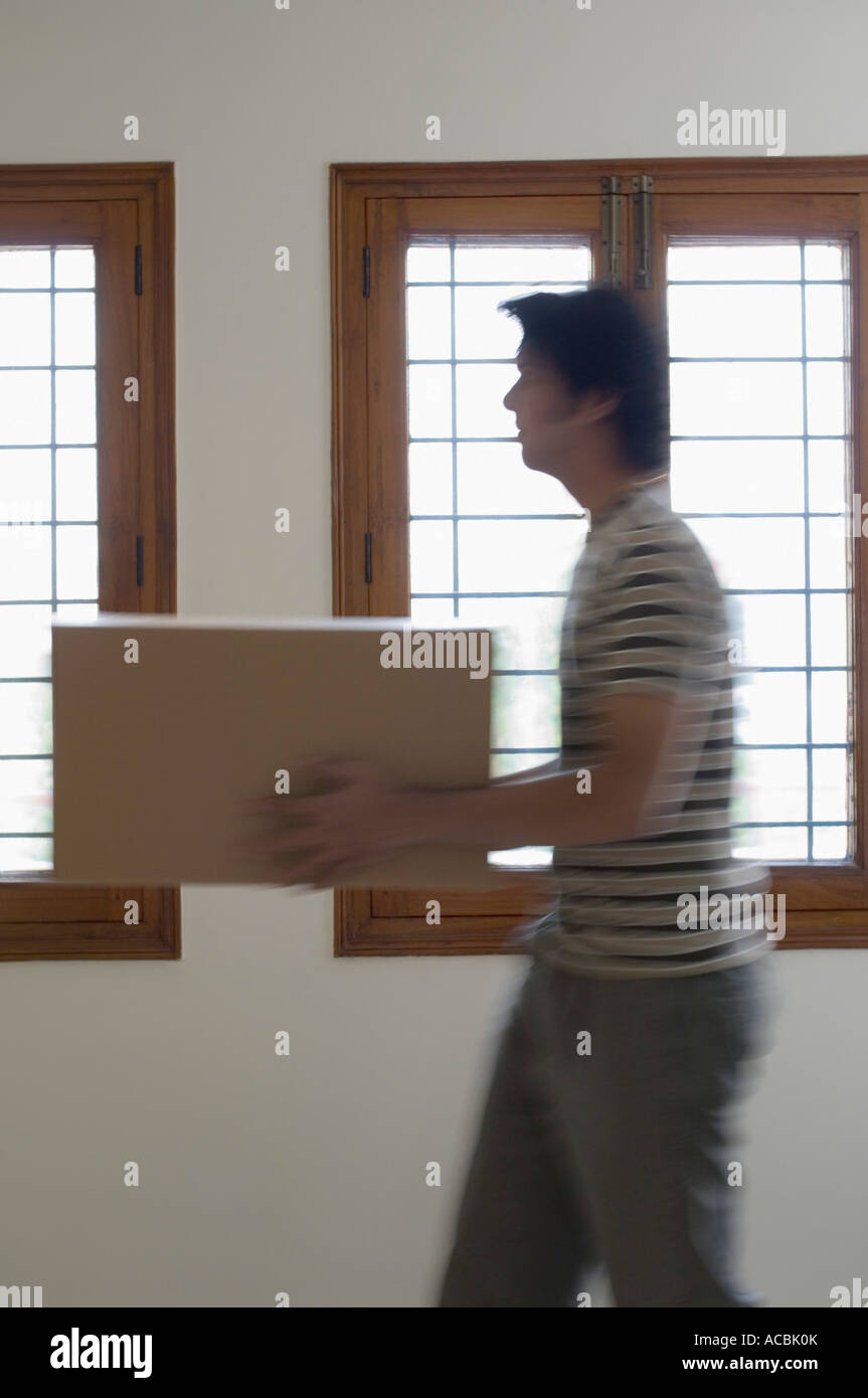 Side profile of a young man carrying a box Stock Photo - Alamy