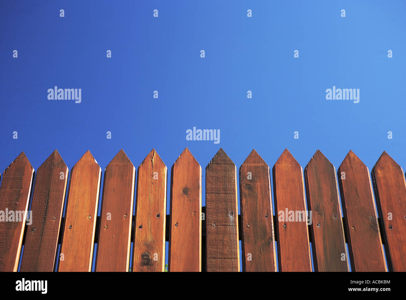 Wooden fence posts against deep blue sky Stock Photo - Alamy