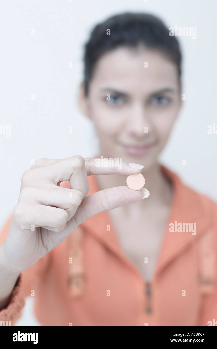 Portrait of a young woman showing a pill Stock Photo - Alamy
