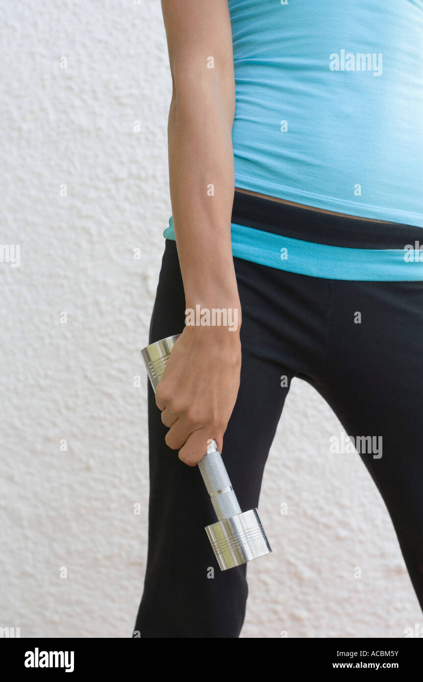 Mid section view of a woman exercising with a dumbbell Stock Photo - Alamy